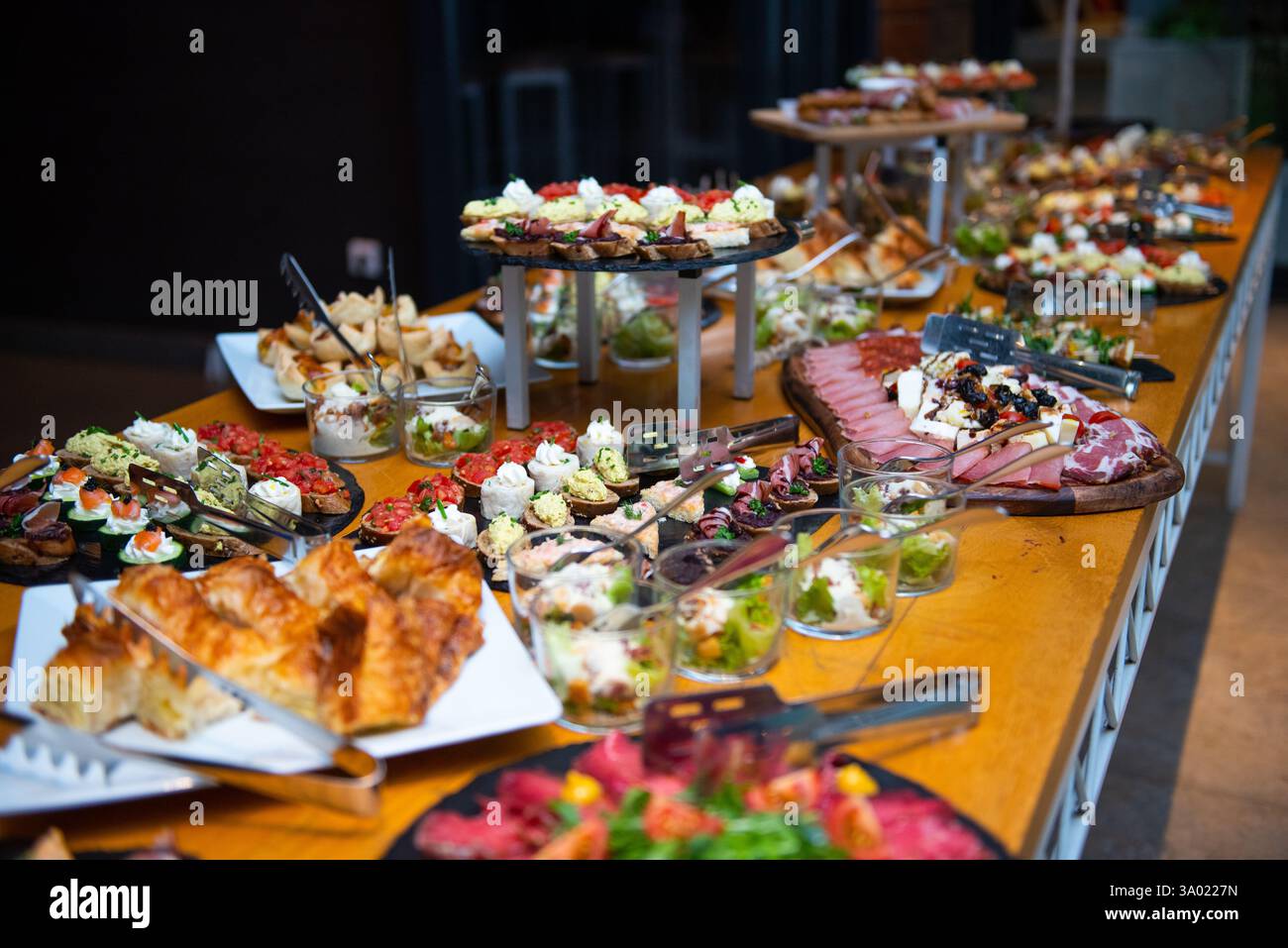 An impressive spread of canapes decorates a long table at a stylish ...