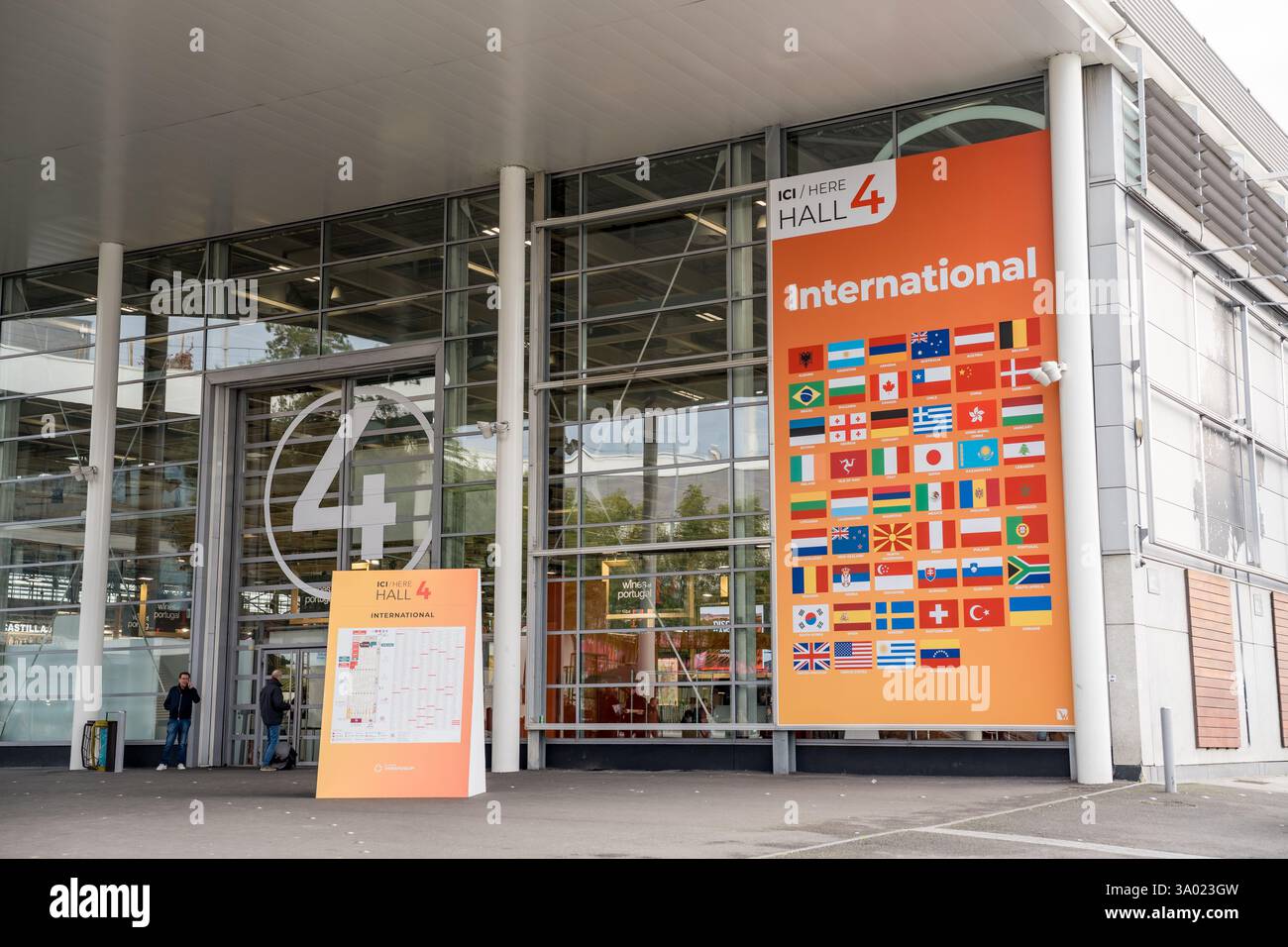 Visitors approach Hall 4 showcasing international flags and welcoming ...