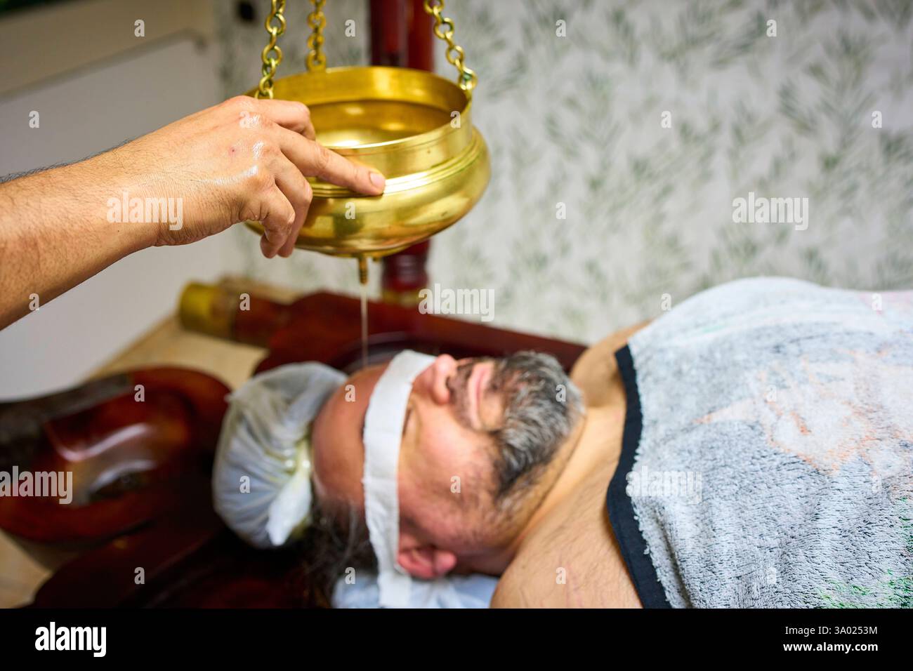 An adult receiving traditional ayurvedic Shirodhara, the Ayurvedic ...