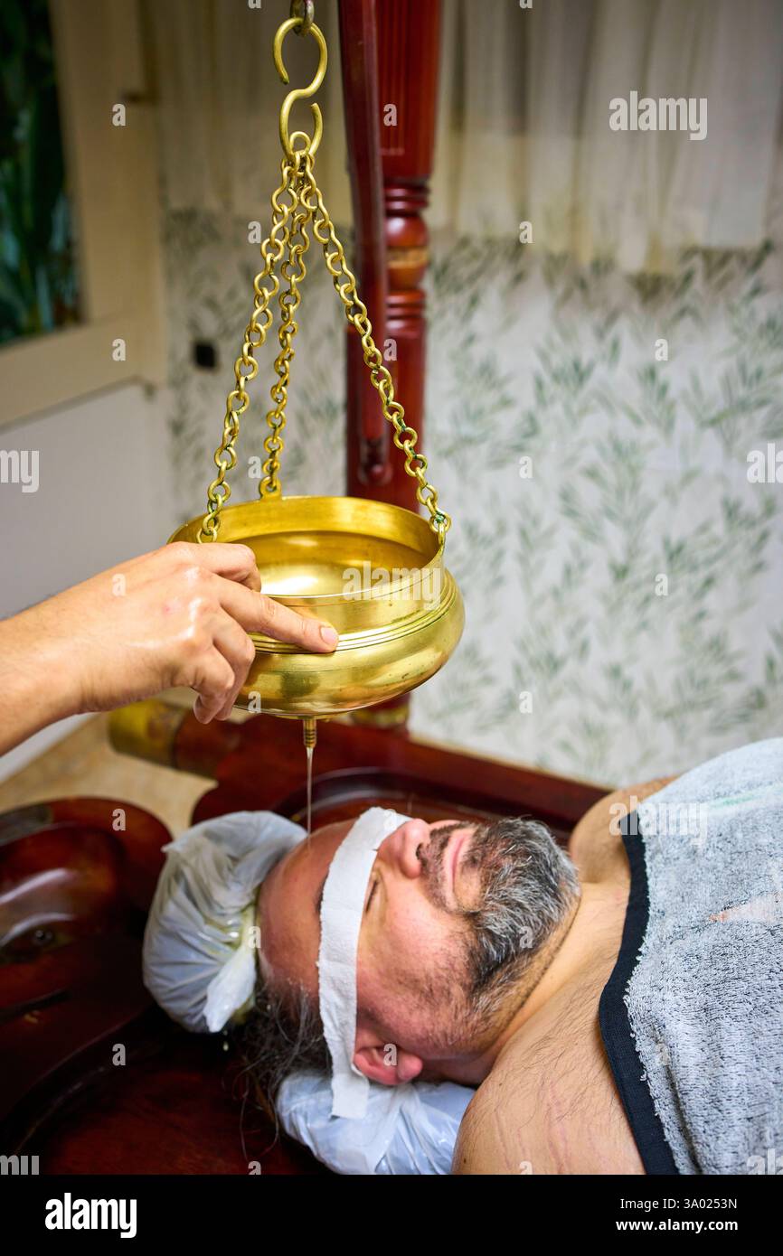An adult receiving traditional ayurvedic Shirodhara, the Ayurvedic ...