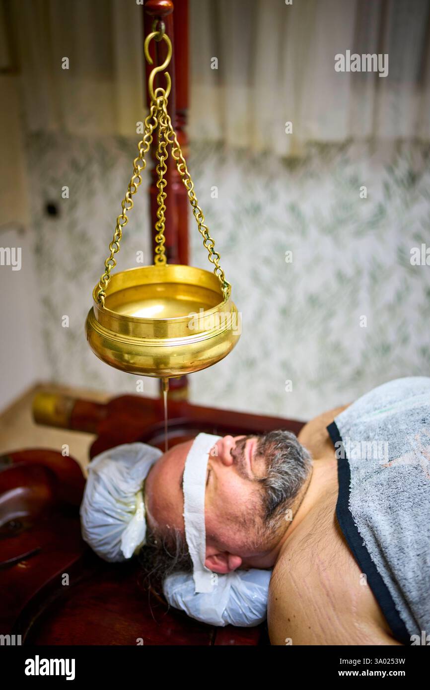 An adult receiving traditional ayurvedic Shirodhara, the Ayurvedic ...