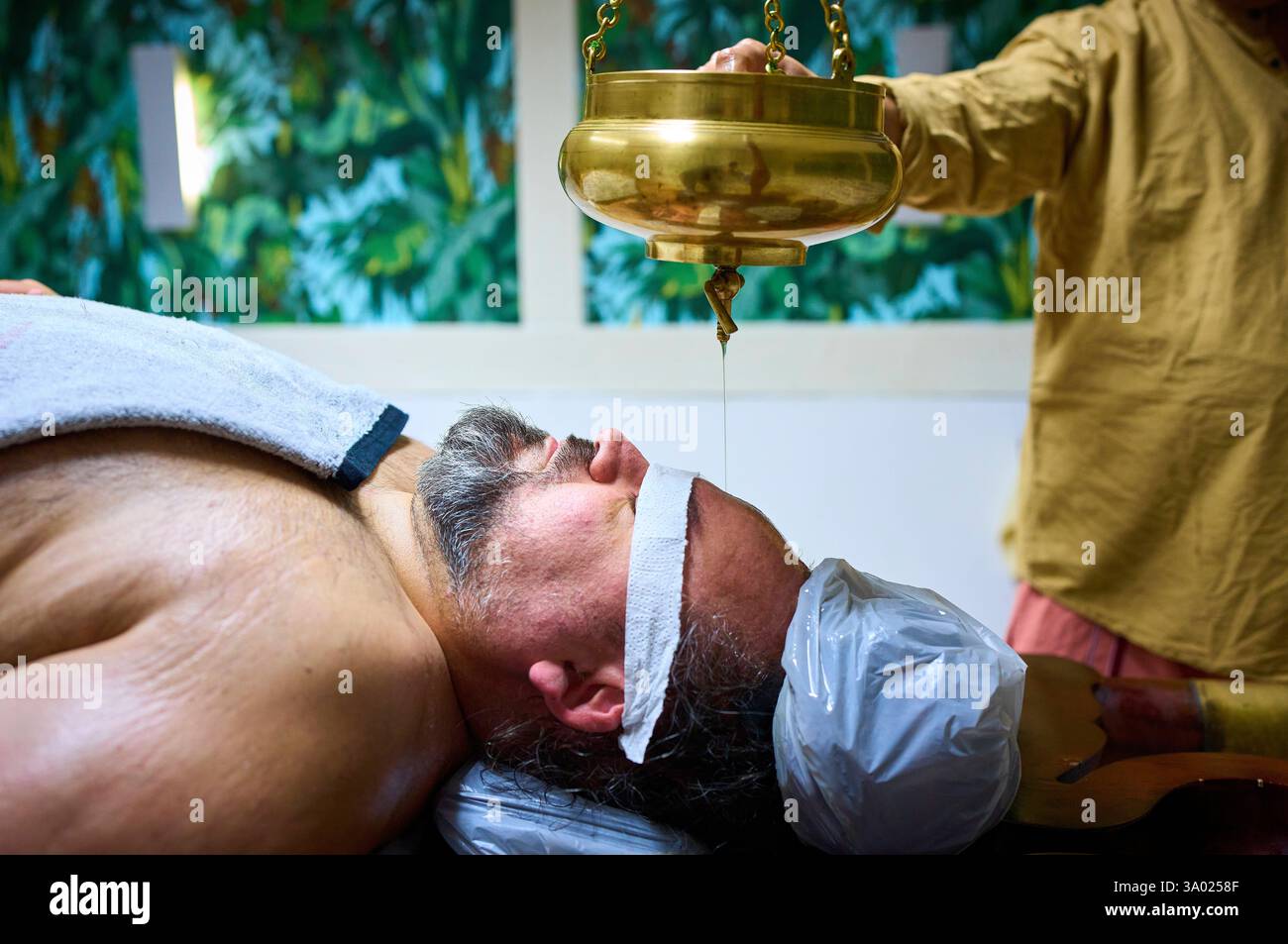 An adult receiving traditional ayurvedic Shirodhara, the Ayurvedic ...