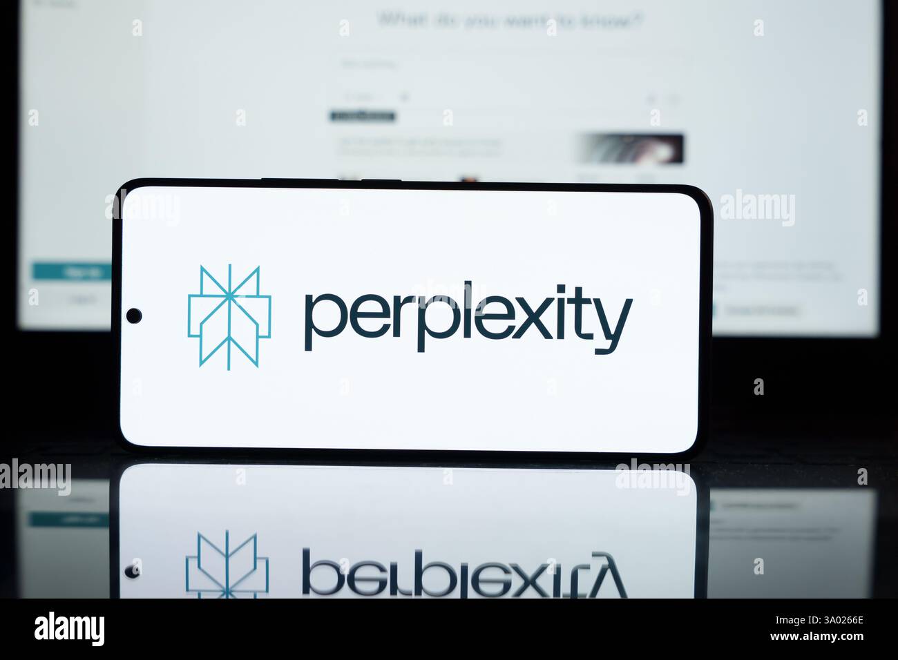 Smartphone displays Perplexity logo. Website screen blurred in ...