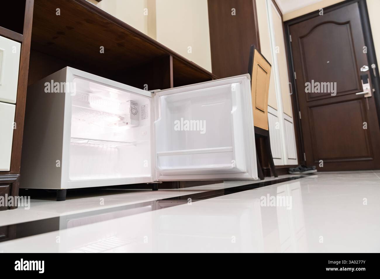 mini fridge in low angle view, inside it’s empty shelves placed under ...