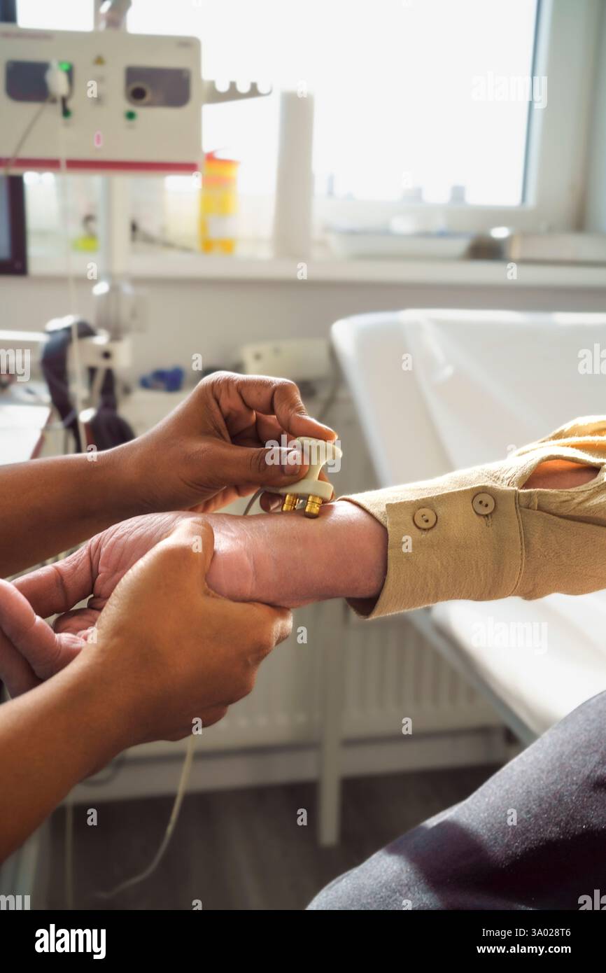 Female doctor checking pulse of senior patient during medical test in ...