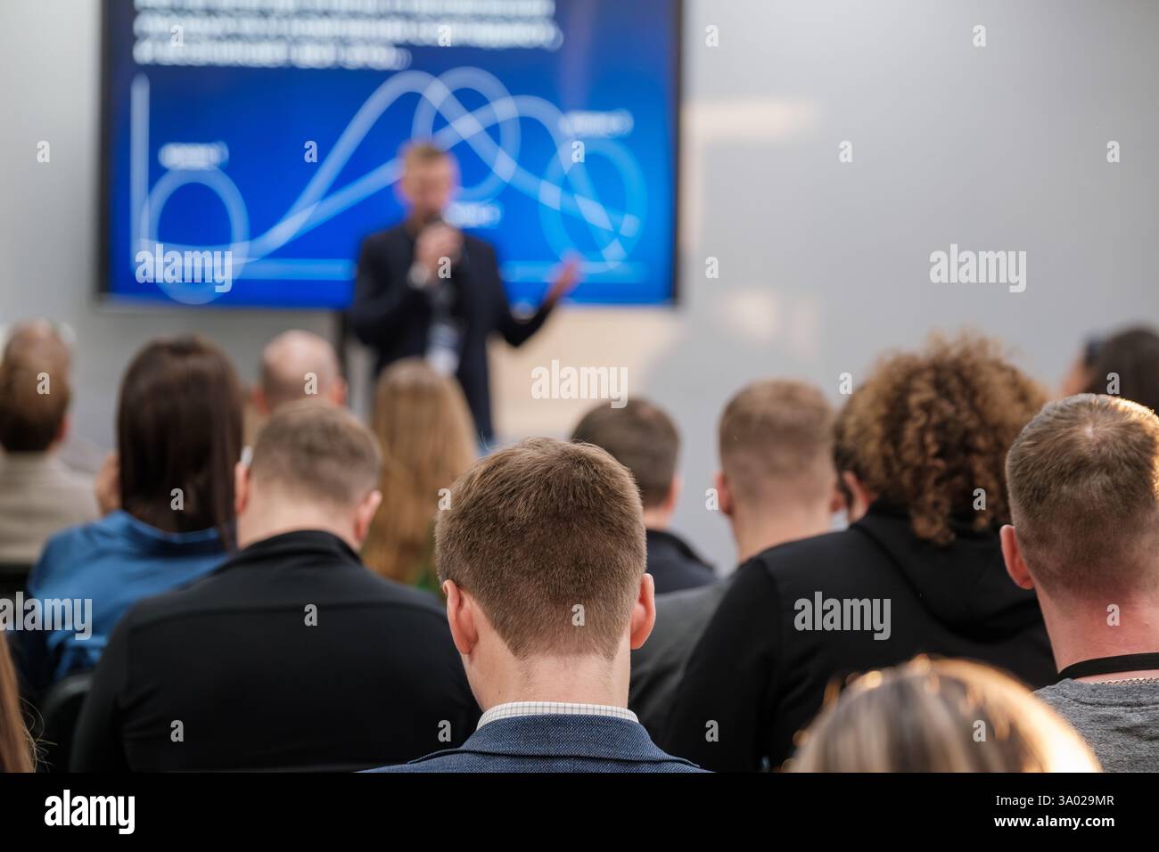 Professional audience engaged in presentation featuring speaker ...