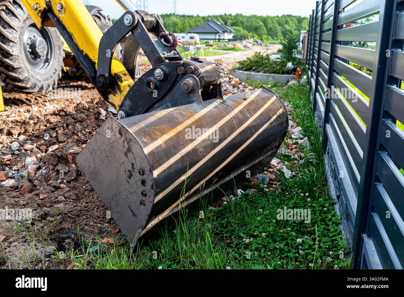 A backhoe loader picks up rubble with a telescopic bucket to level the ...