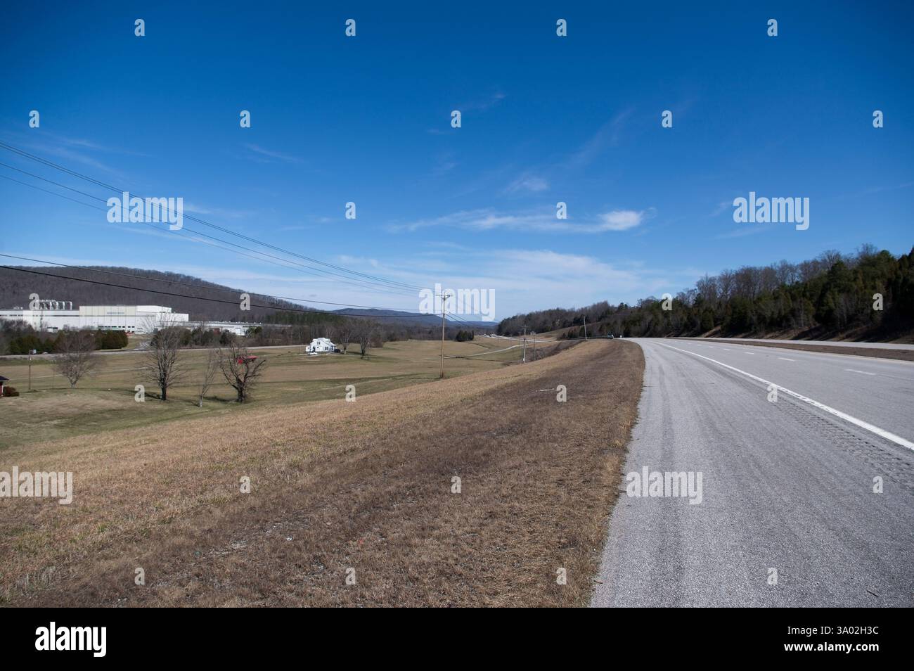 Highway with factory and house on the left Stock Photo - Alamy