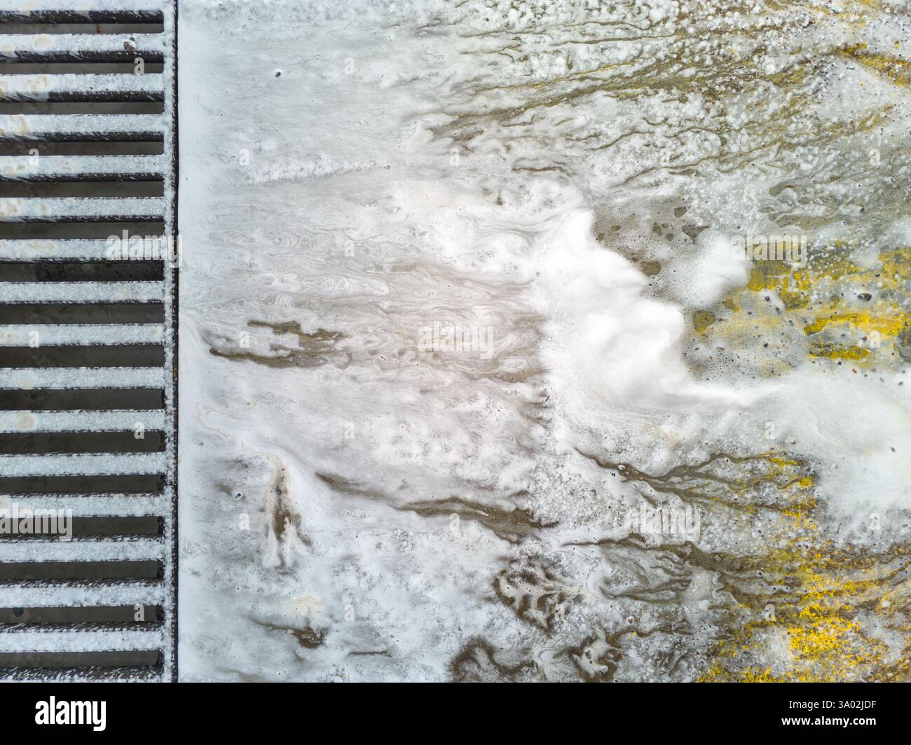 Soap sud waste flows to floor drain grid in car washing garage, close ...