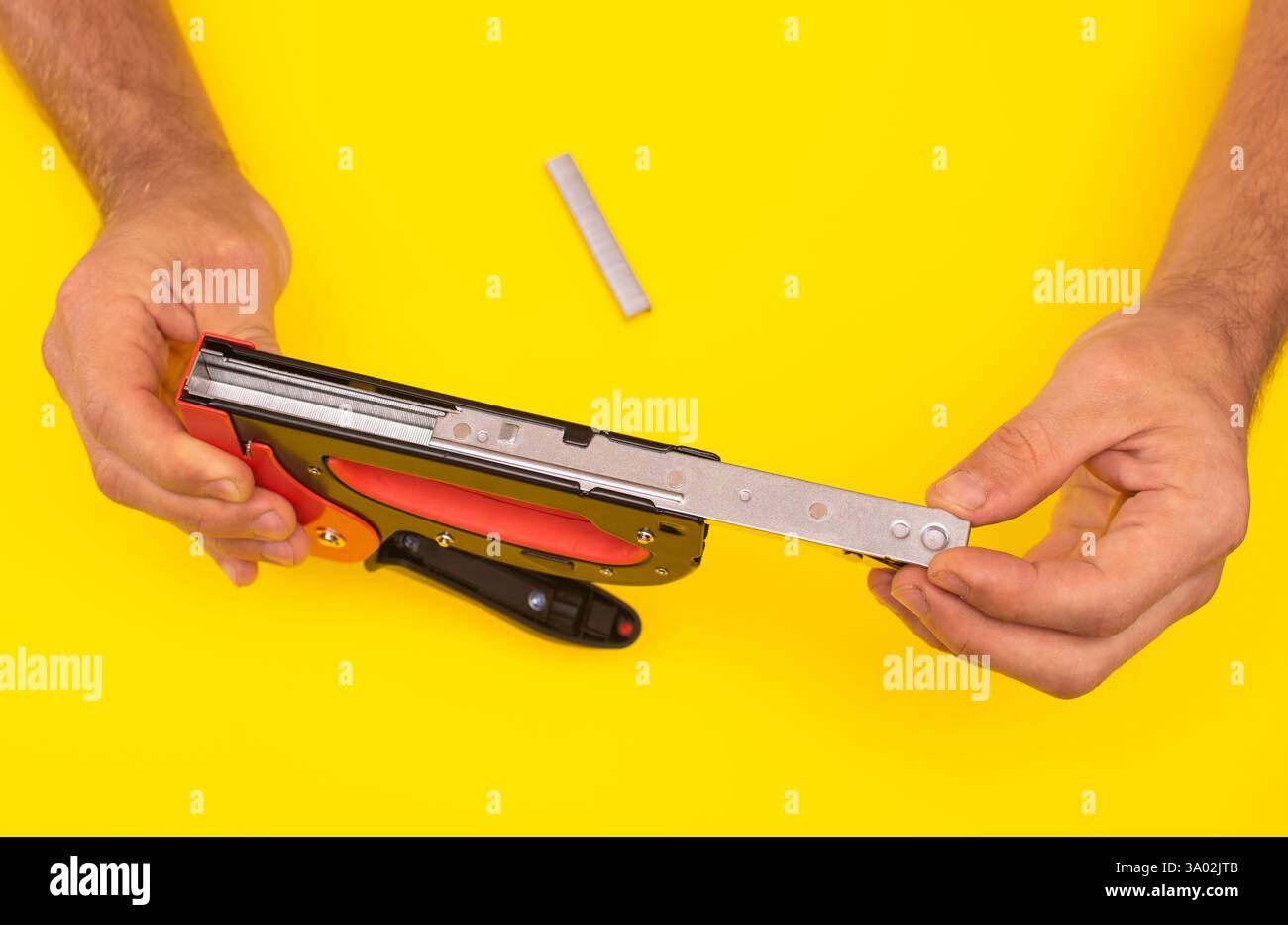 male hands fill the stapler gun with staples Stock Photo - Alamy