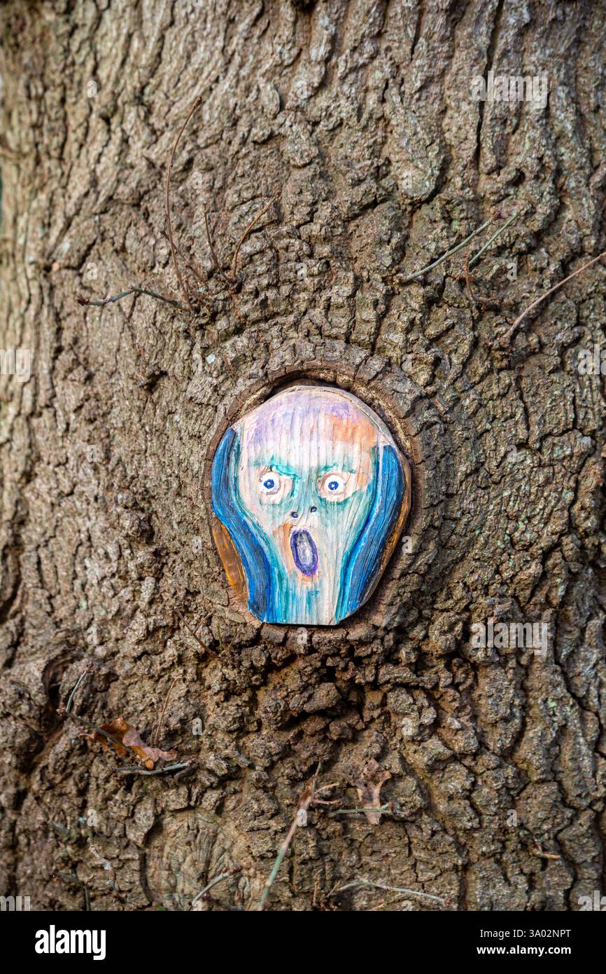 Drawing of screaming face in hole of tree trunk Stock Photo - Alamy