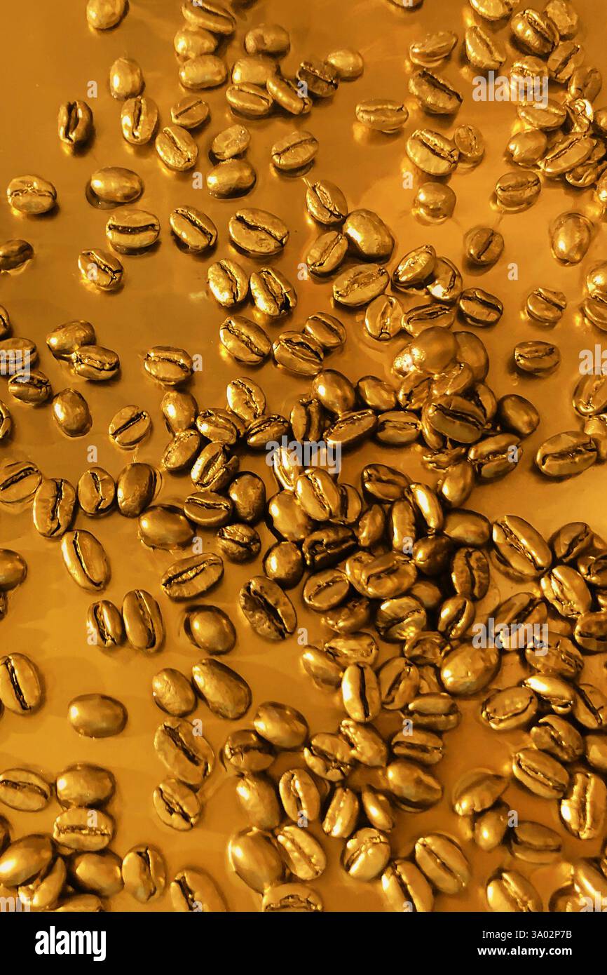 Coffee beans on a golden yellow expensive background texture. A ...