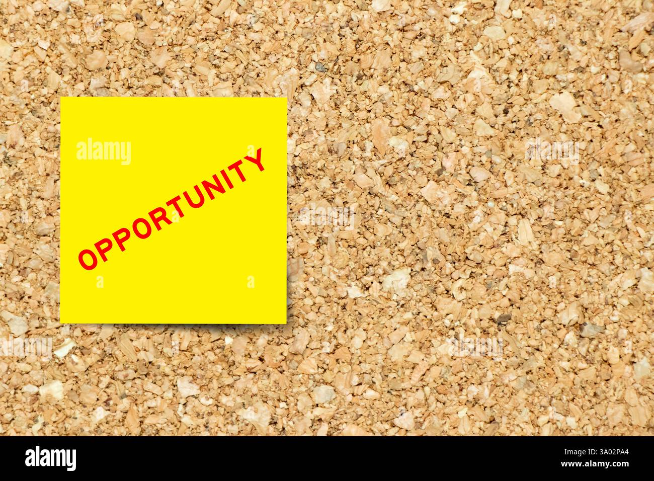 Yellow note paper with word opportunity on cork board background with ...