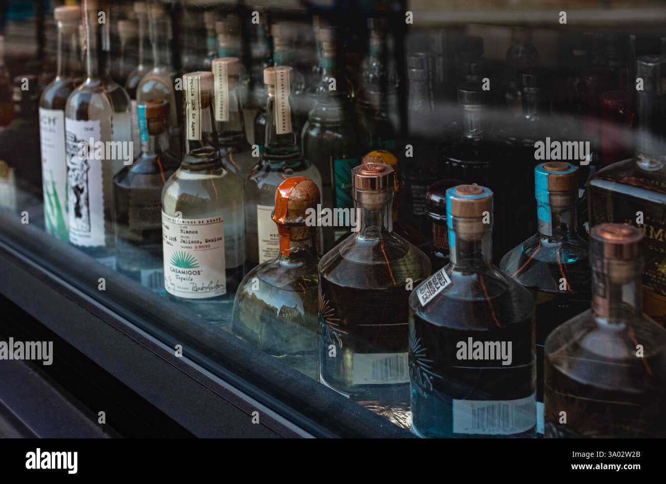 Different bottles of alcohol are displayed on shelves of store. Various ...