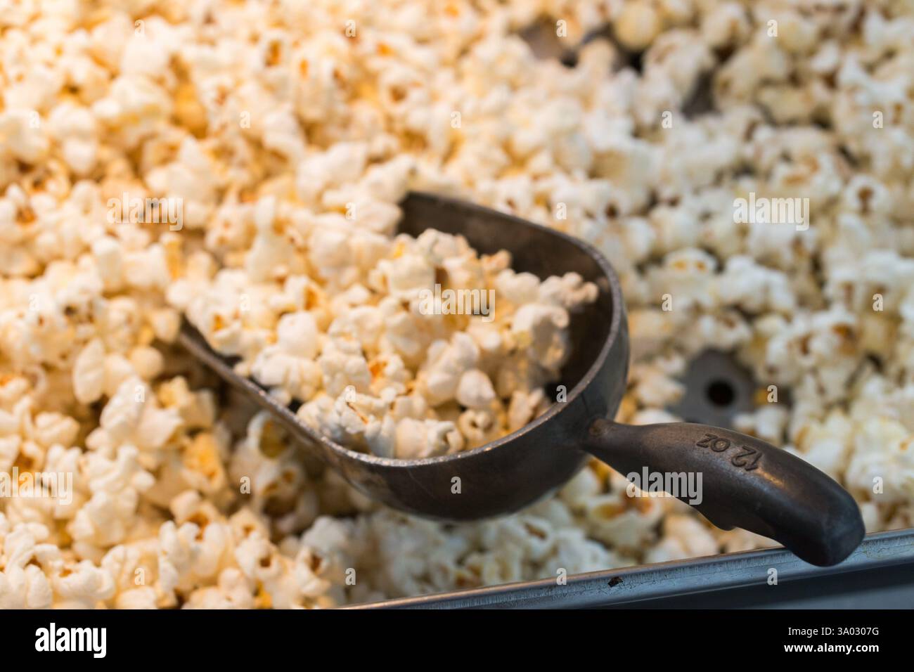 Popcorn scoop full of freshly popped popcorn at a movie theater Stock ...