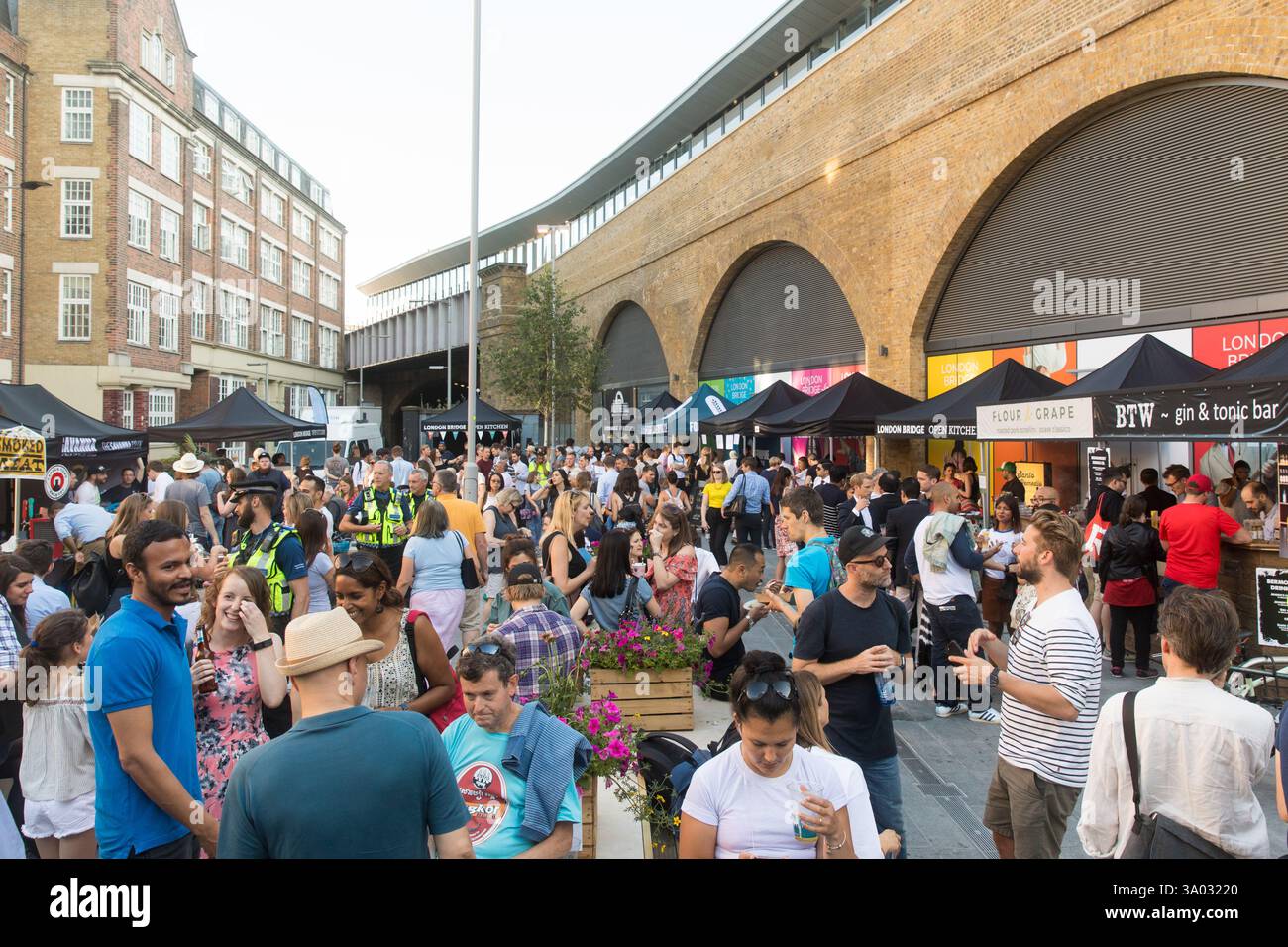 Crowd gathers at London Bridge Open Kitchen food stalls, under arches ...