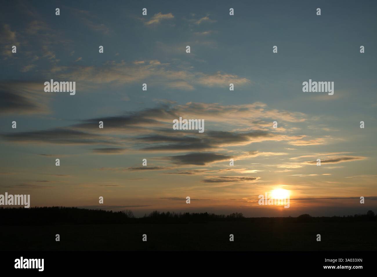 The setting sun paints the sky in warm shades, penetrating through the ...