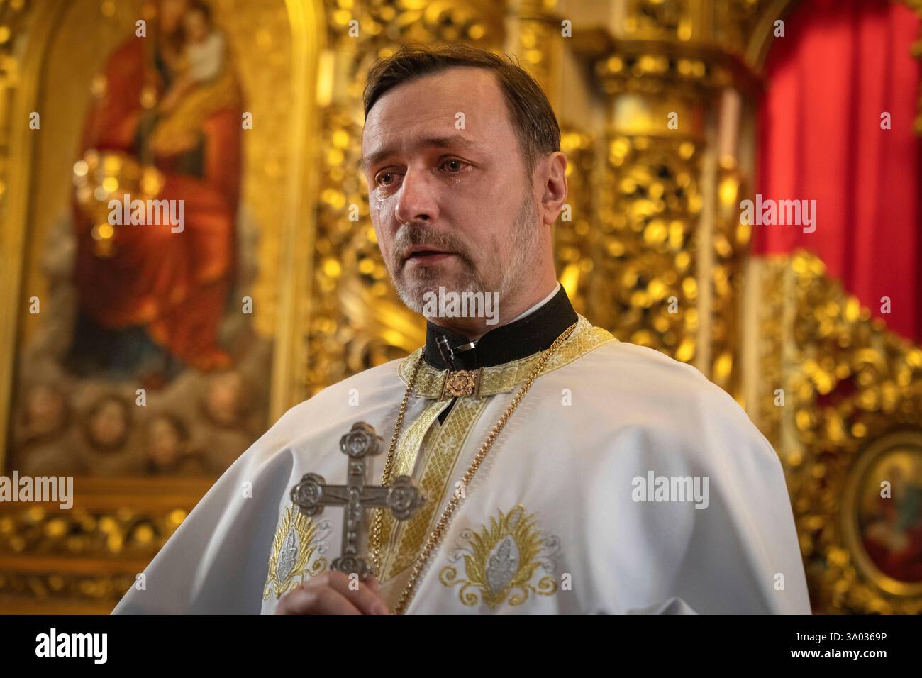 A priest cries as he conducts a funeral service for volunteer soldier ...