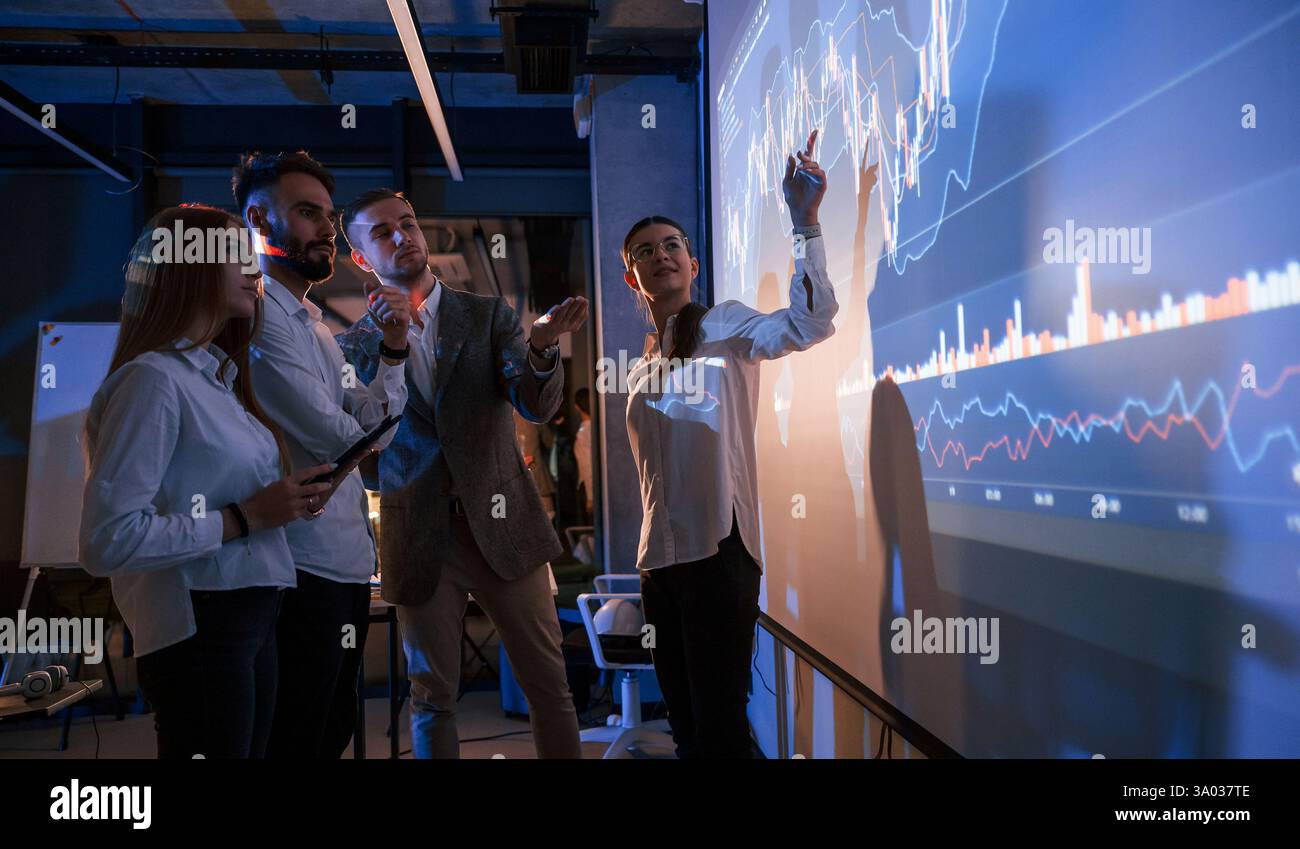 Standing together. Male leader talking to employees, showing the plan ...