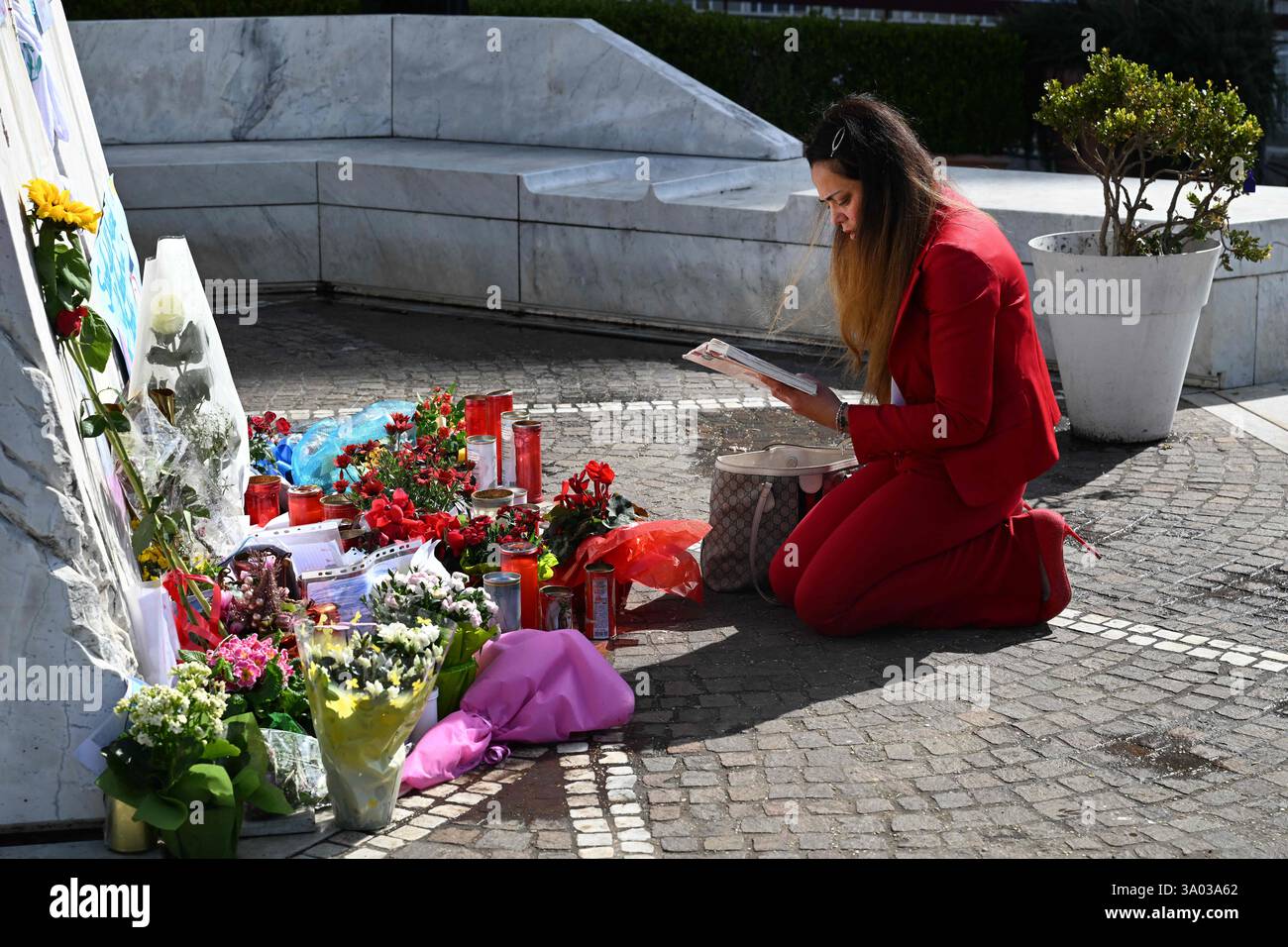 People pray near the statue of John Paul II outside the Gemelli ...