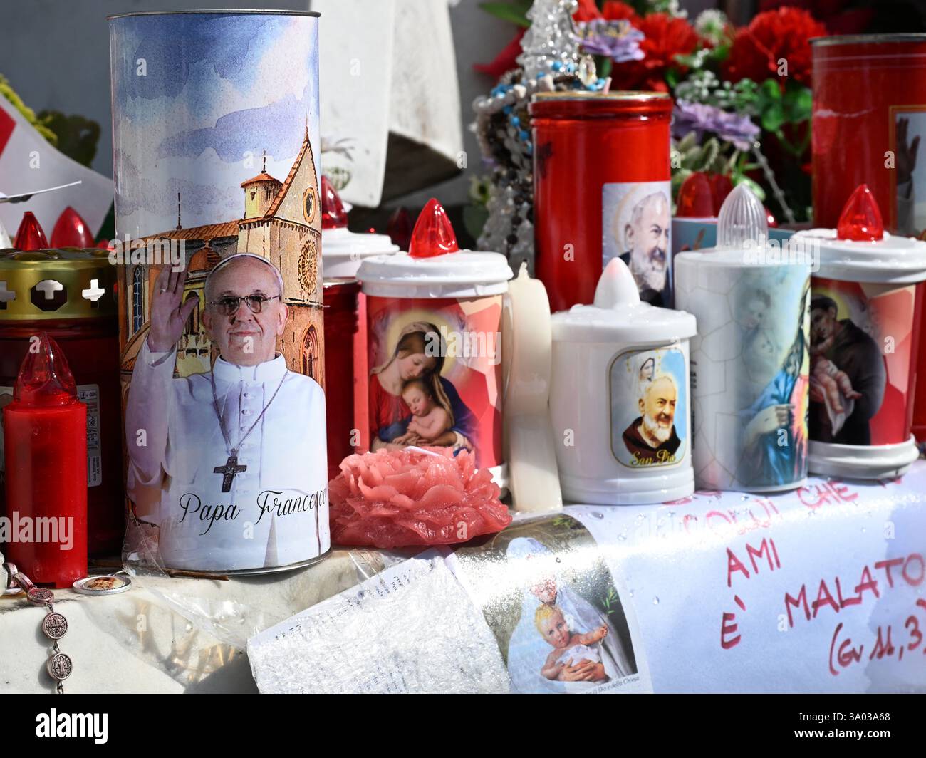 People pray near the statue of John Paul II outside the Gemelli ...