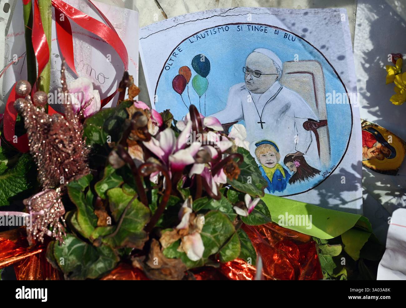 People pray near the statue of John Paul II outside the Gemelli ...