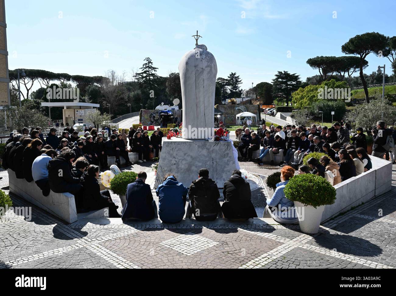 People pray near the statue of John Paul II outside the Gemelli ...