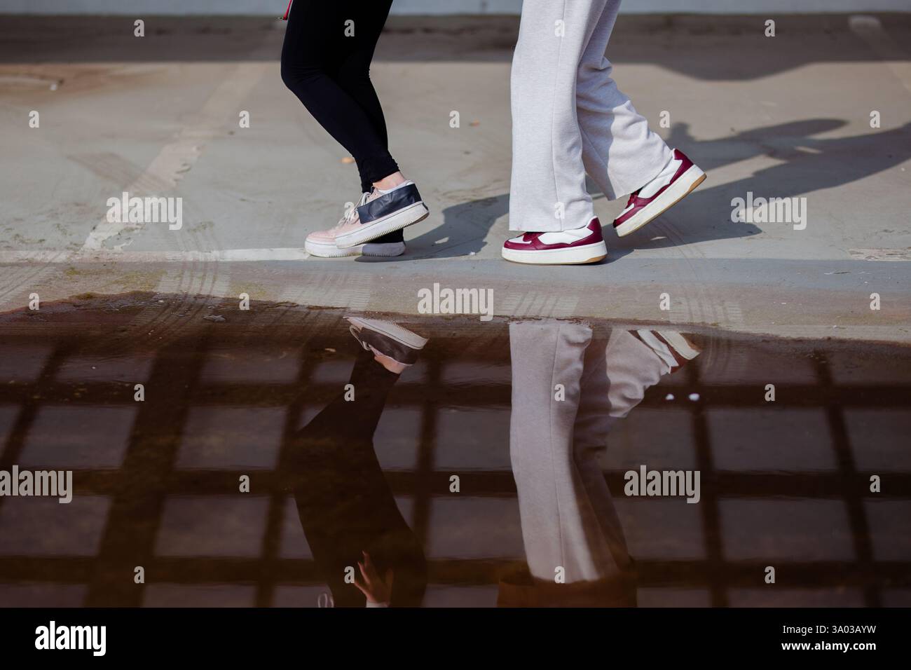 Two people depicted walking together on a flat outdoor surface while ...
