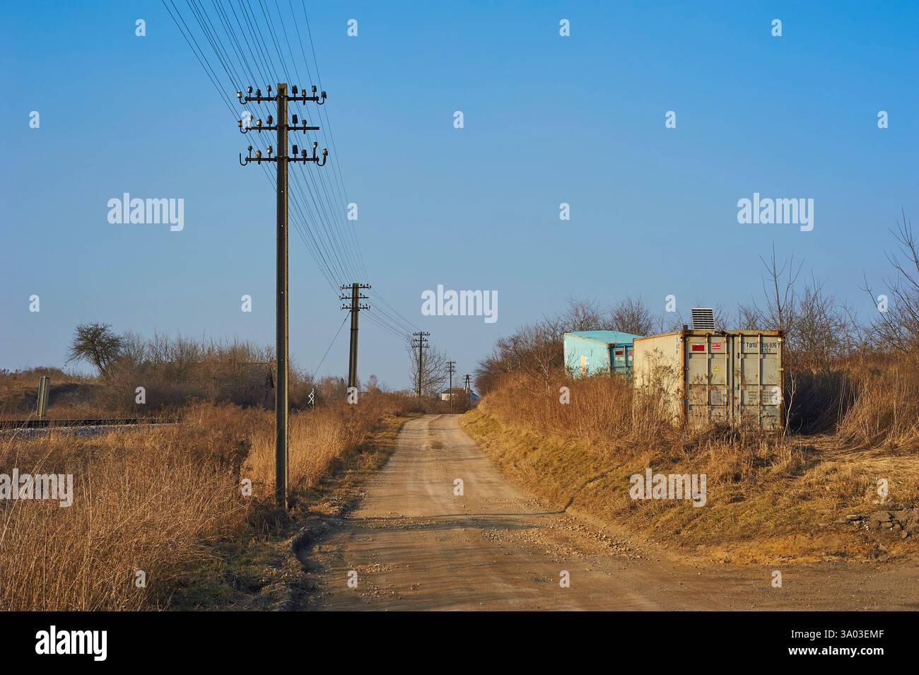 Rural Dirt Road With Utility Poles and Containers in a Countryside ...