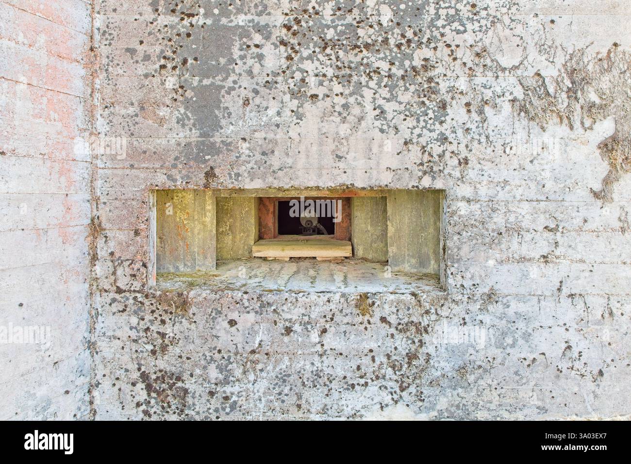 Closeup of an old machine gun opening in a old concrete WW2 bunker with ...