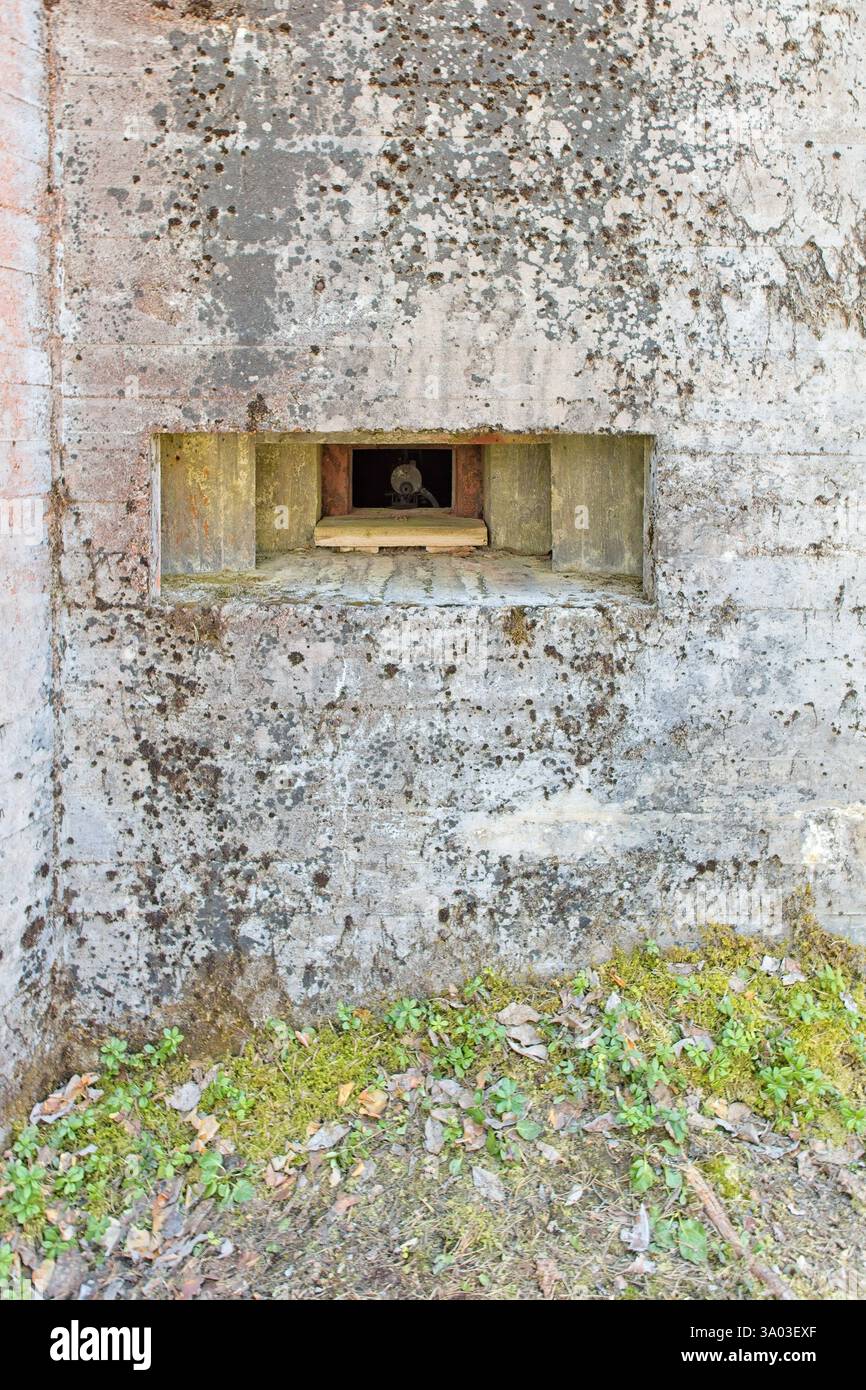 Closeup of an old machine gun opening in a old concrete WW2 bunker with ...