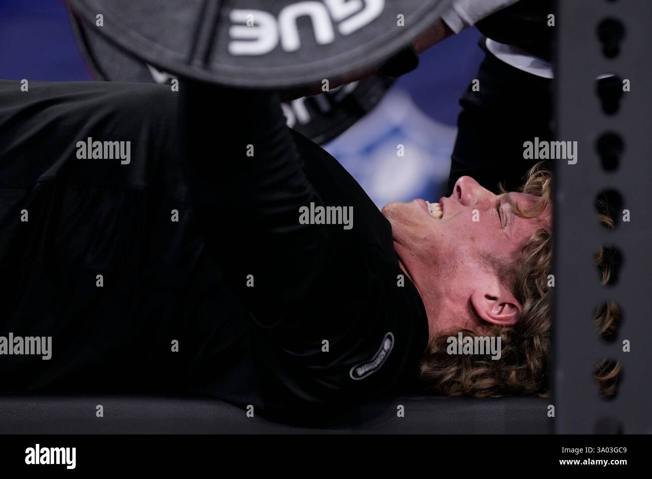 Arkansas wide receiver Isaac TeSlaa lifts weights at the NFL football ...