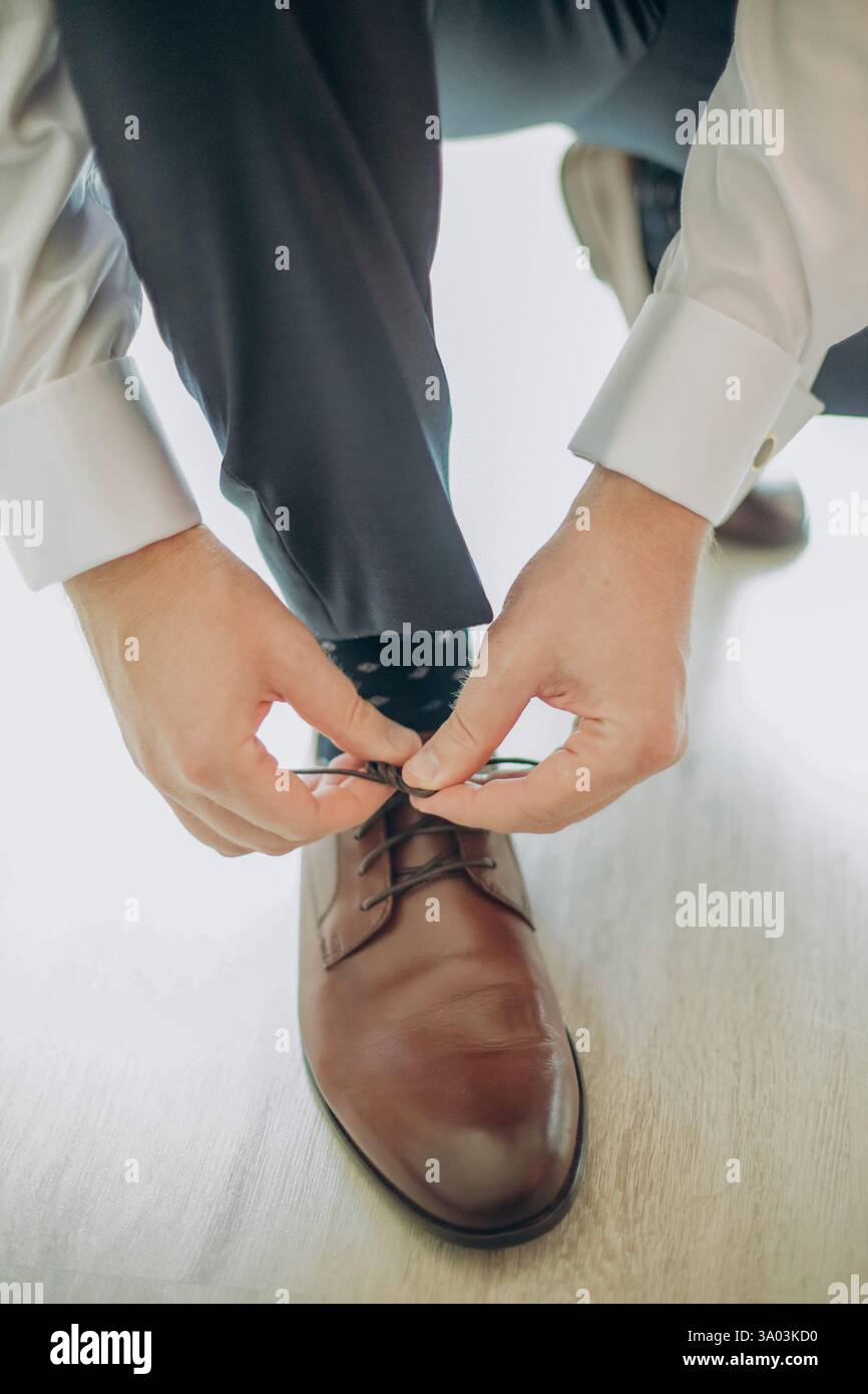 Groom putting on elegant leather shoes for his wedding, men's wardrobe ...