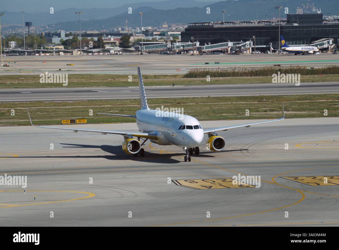 Full image of white jet airplane parked on tarmac at large airport with ...