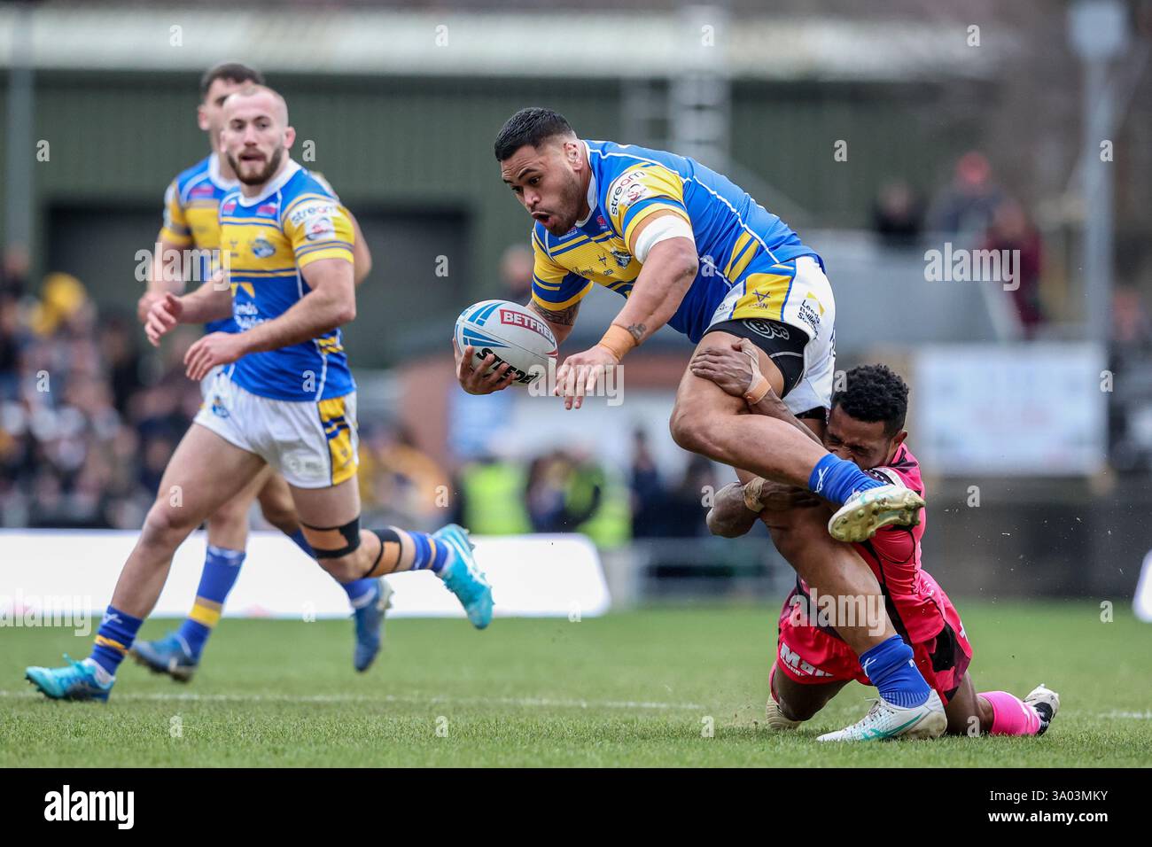 Sam Lisone of Leeds Rhinos is tackled by George Griffin of Castleford ...