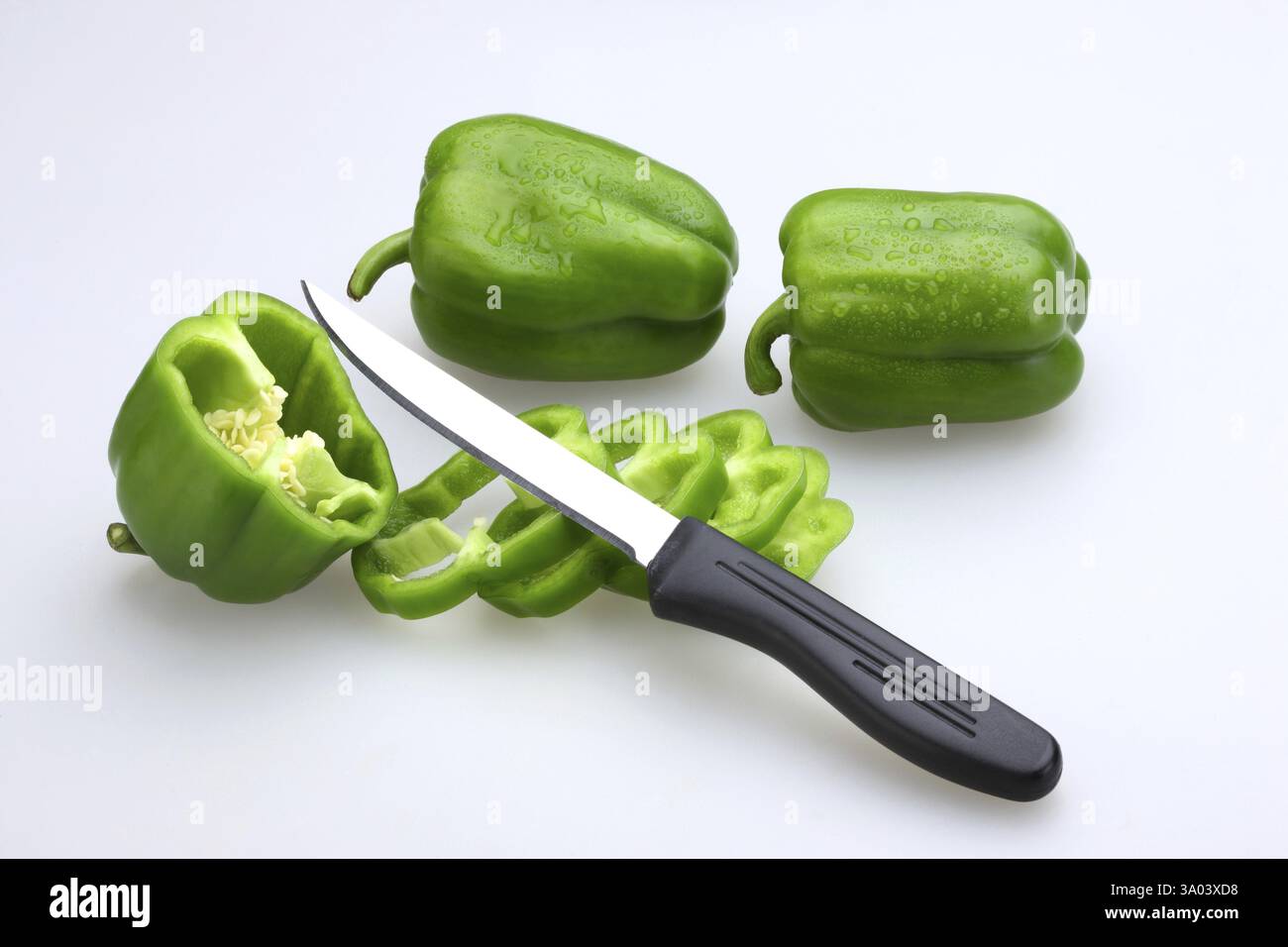 Sharp knife with black handle with slices of Green Capsicums Latin ...