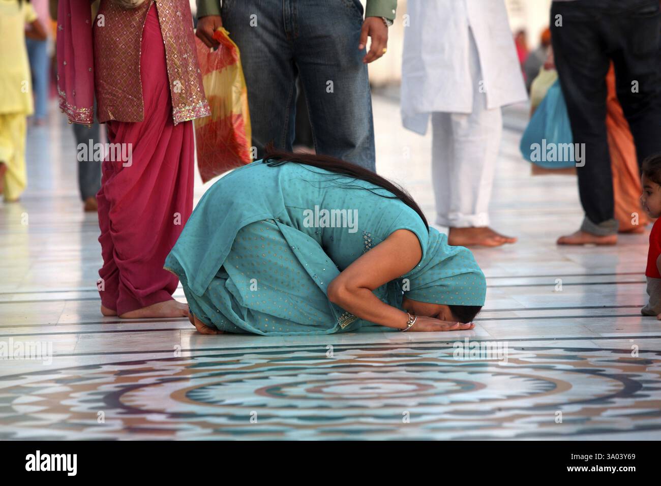 Girl bowing pay her respects to Harmandir Sahib or Darbar Sahib or ...