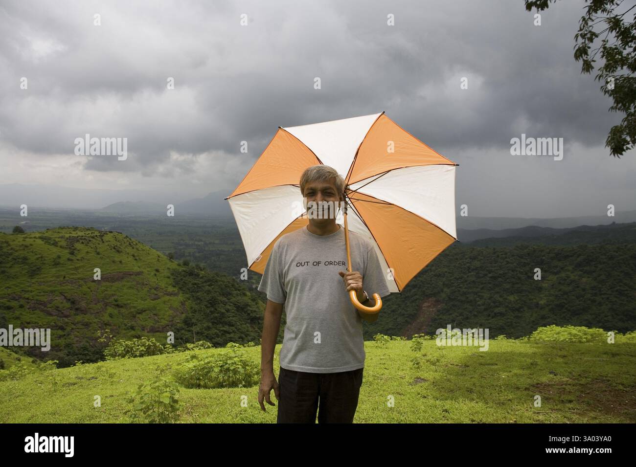South Asian Indian man holding umbrella, Jummapatti, Matheran ...