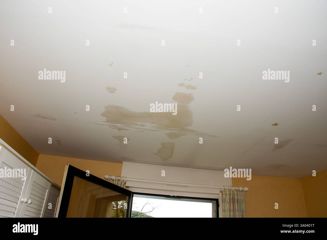 Water stains on ceiling in room revealing potential roof leak during ...