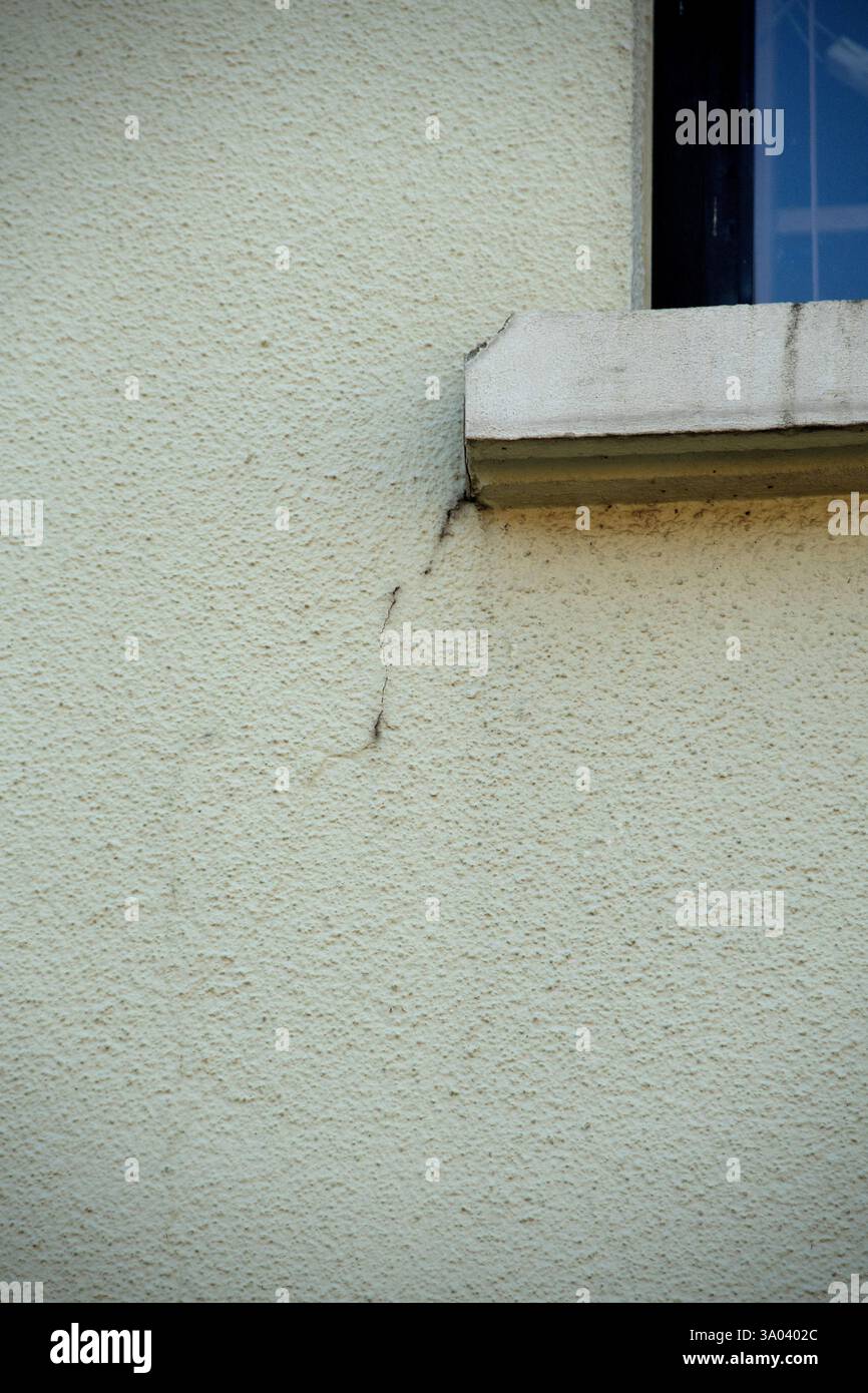 Significant crack observed on building exterior near window indicating ...