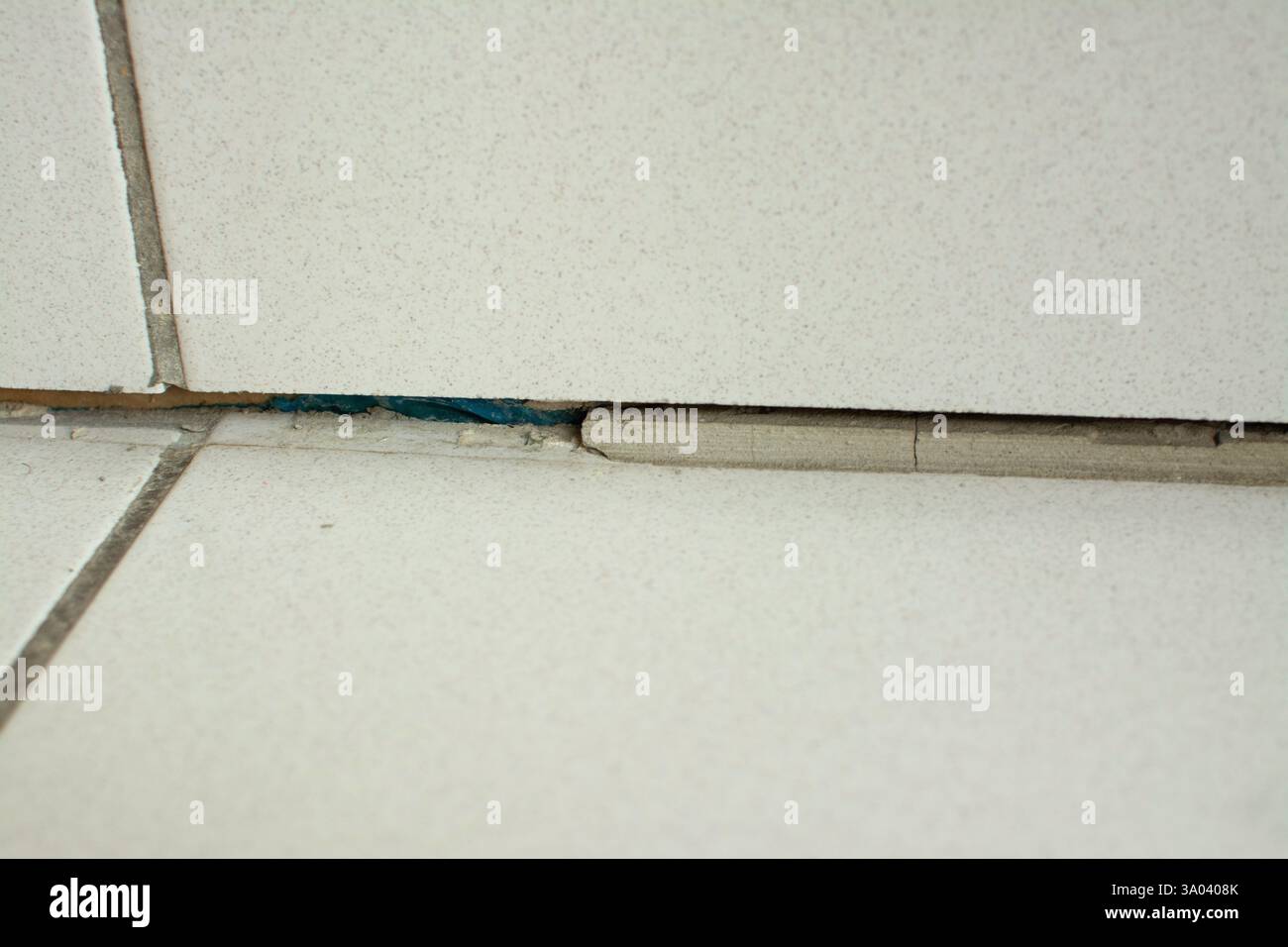 Cracked grout between tiles reveals underlying damage and potential ...