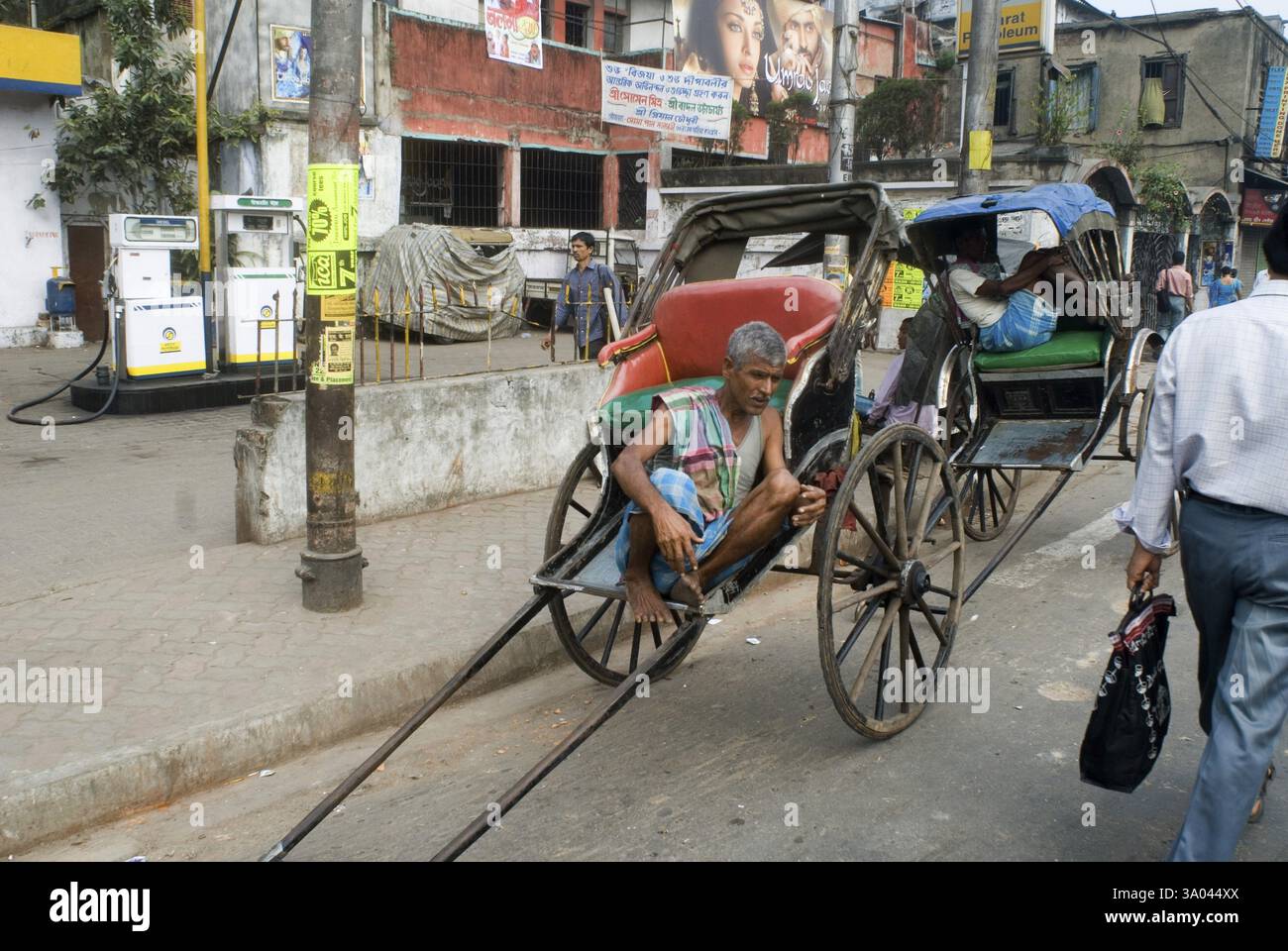 Hand Rickshaw Puller sitting in his Rickshaw on street waiting for ...