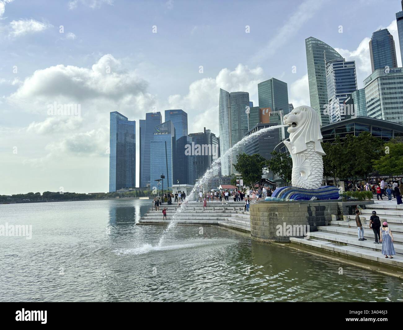 Merlion fountain spouts water in front of the impressive skyline and ...