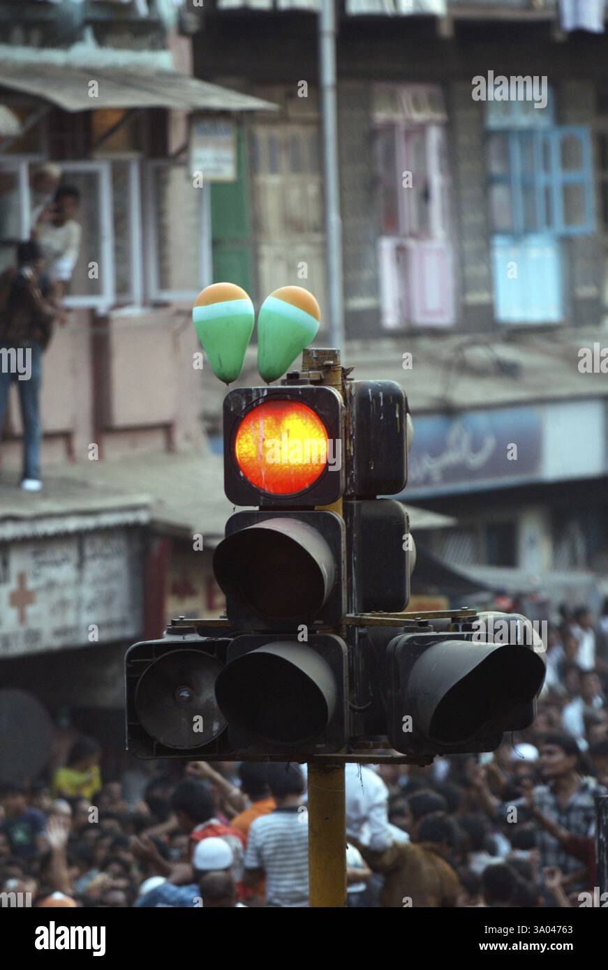 Balloons tied on signal showing red light at traffic junction in Bombay ...