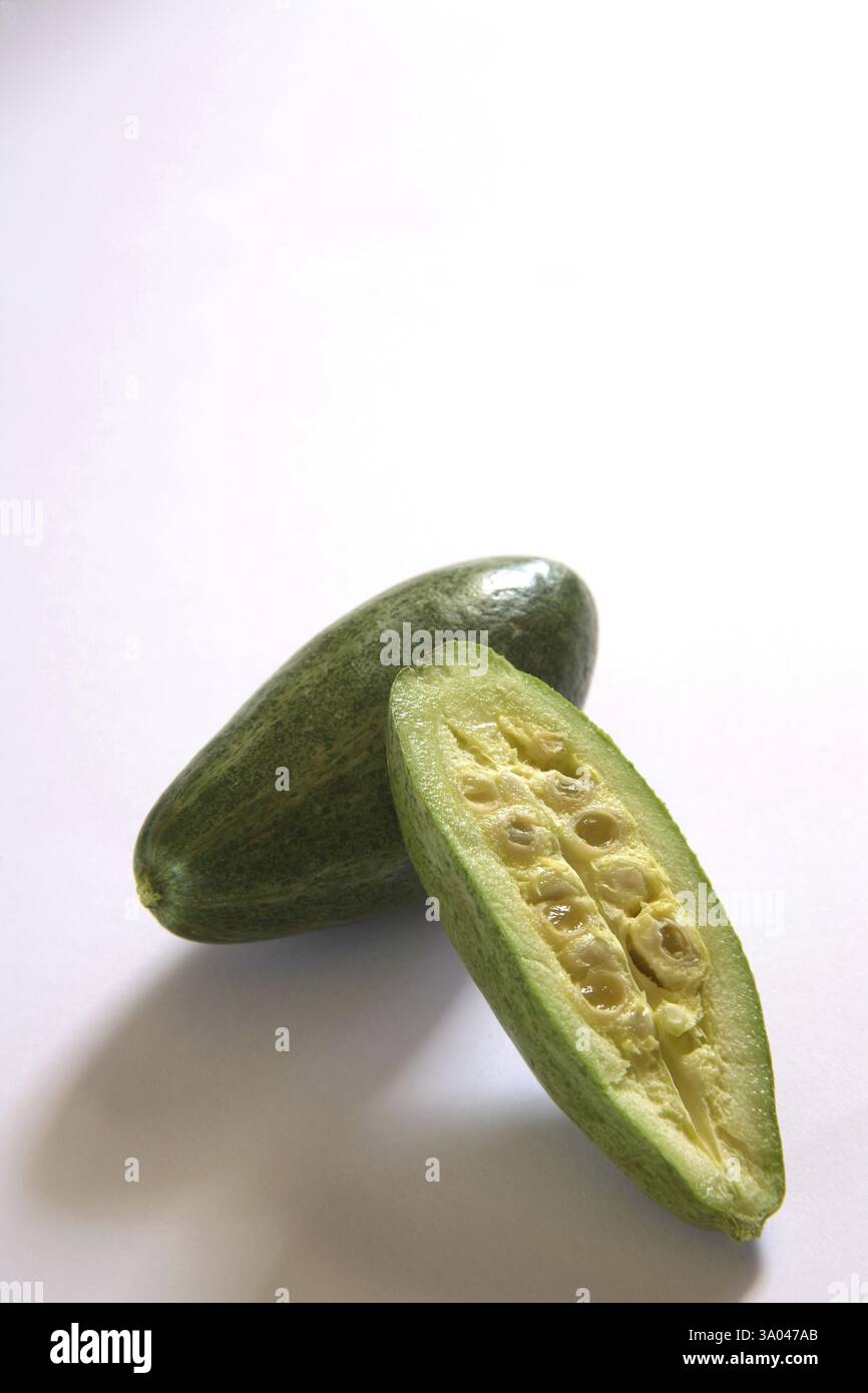 Vegetable, one full and half striped pear gourds parwal on white ...