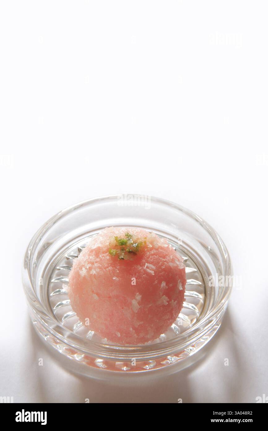 One piece of bengali mithai raskadam garnish with coconut and pistachio ...