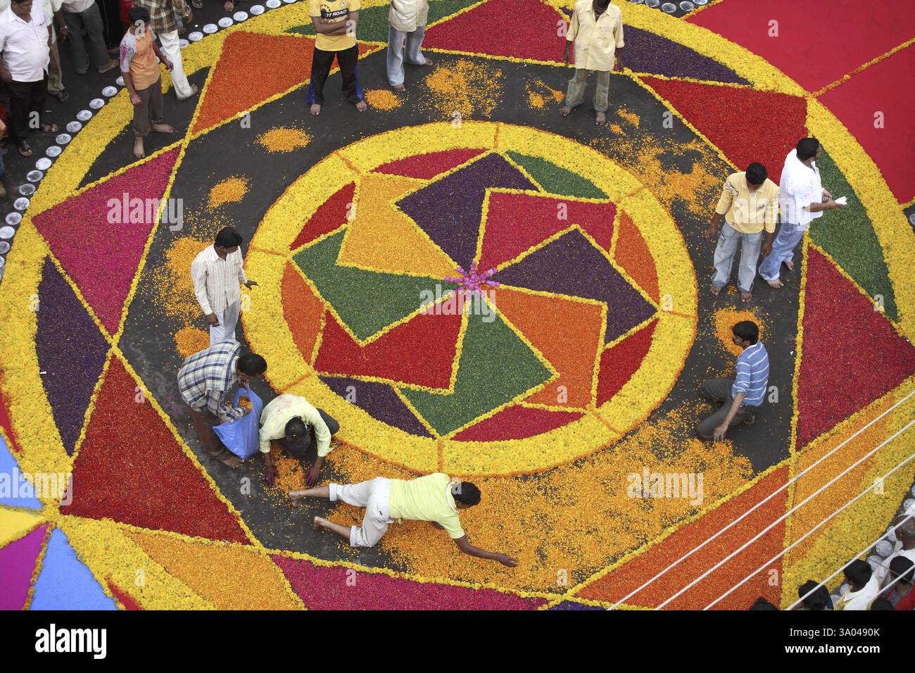 Residents making colourful flower Rangoli on road for immersion ...