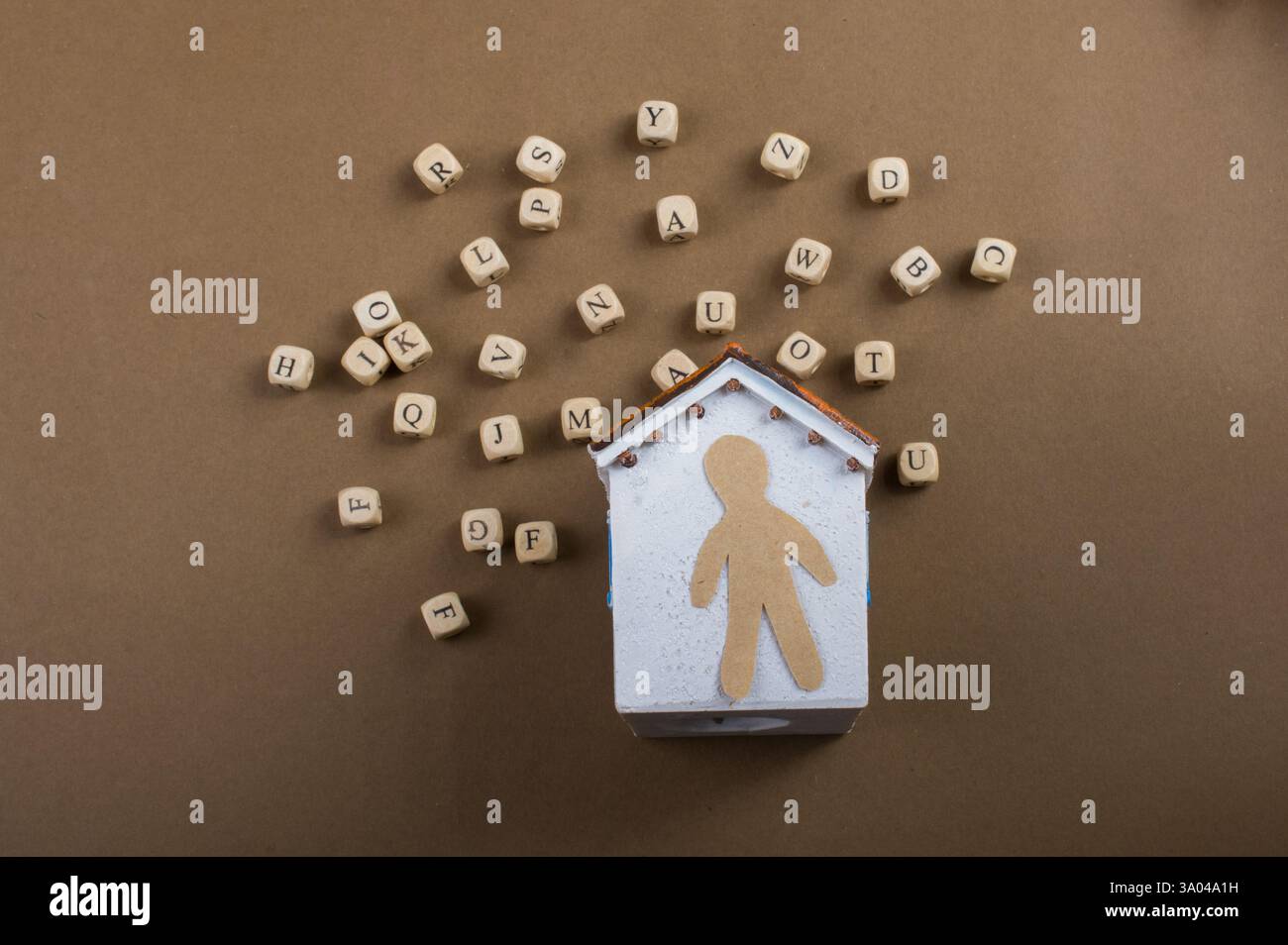 Wooden letter cubes and man figurine and model house Stock Photo - Alamy