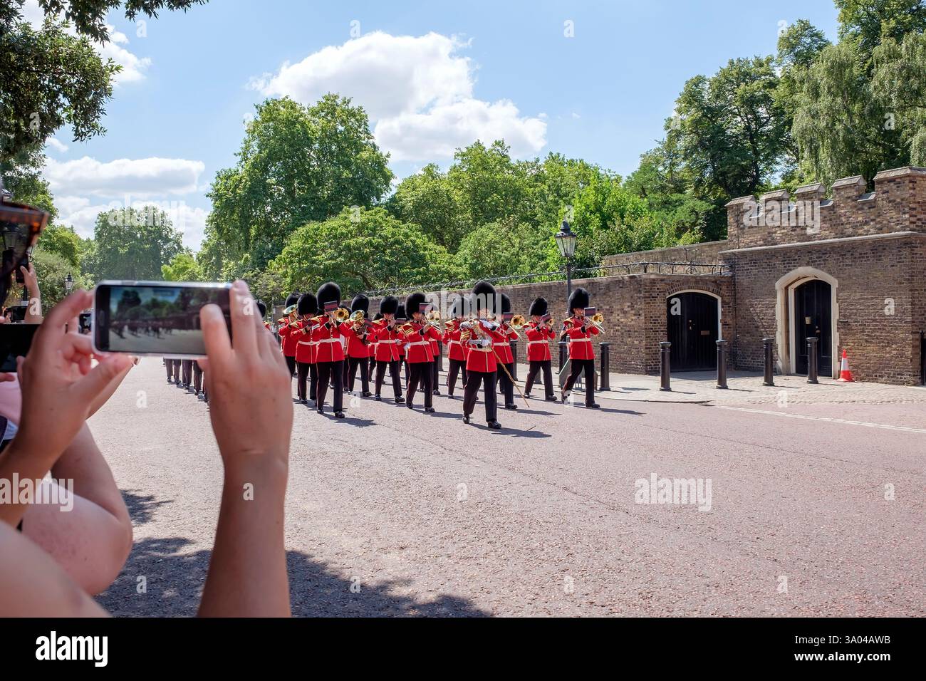 A marching band of British guards in red uniforms and black bearskin ...