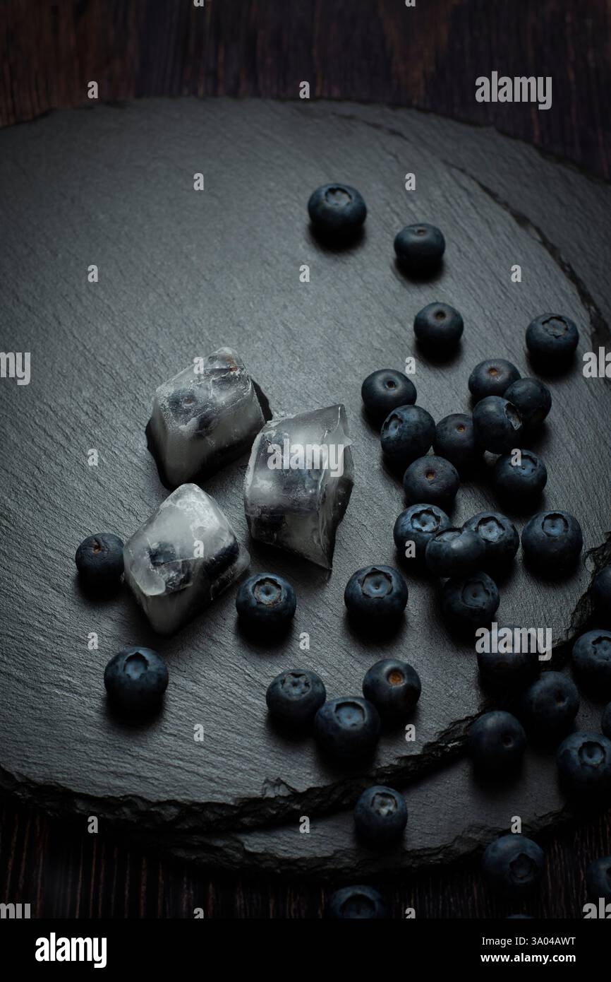 Blueberry ice cubes and blueberries on a black stone tray Stock Photo ...